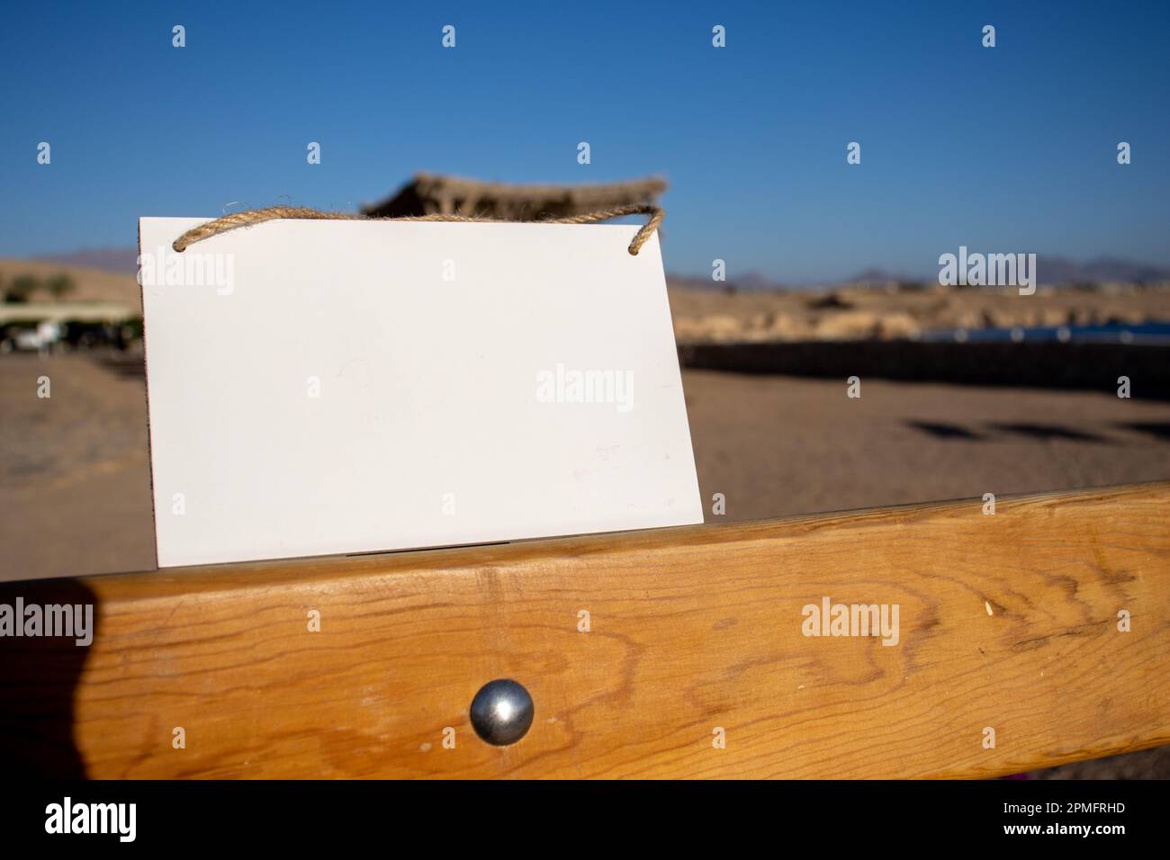 white hanging picture sign resting on a park bench with empty free ...