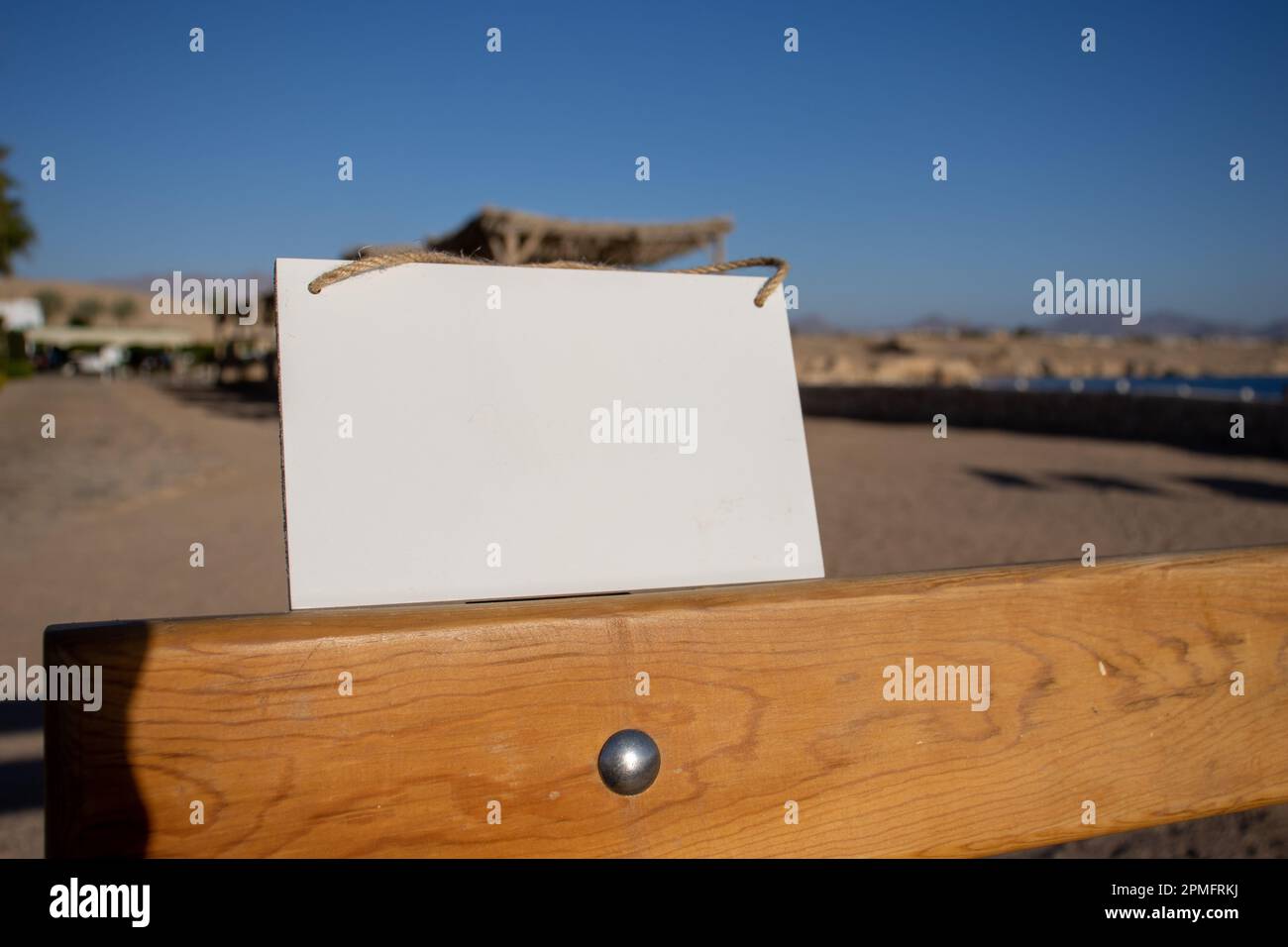 white hanging picture sign resting on a park bench with empty free ...