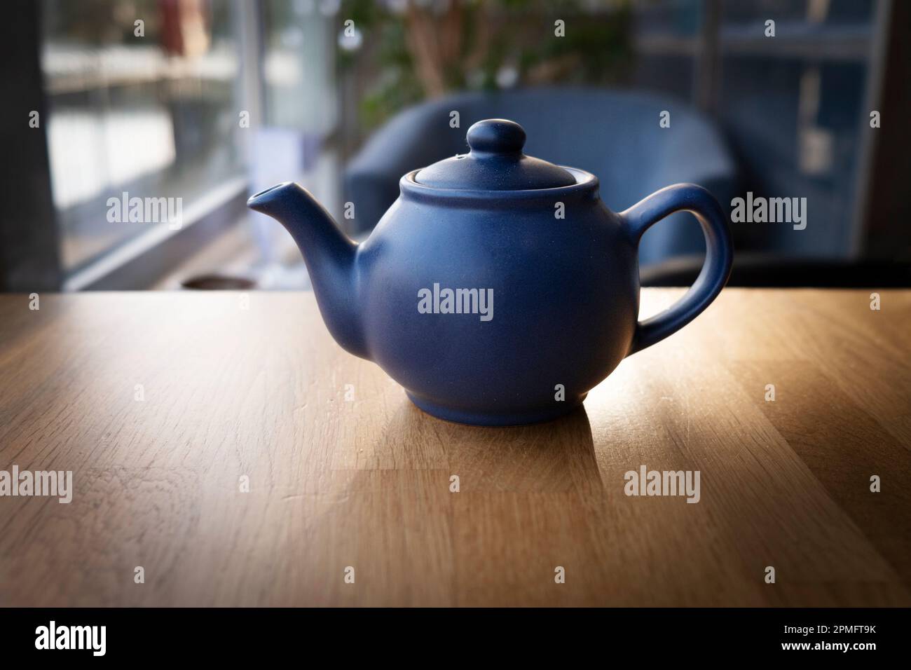 A dark blue ceramic teapot on a table in a restaurant Stock Photo - Alamy