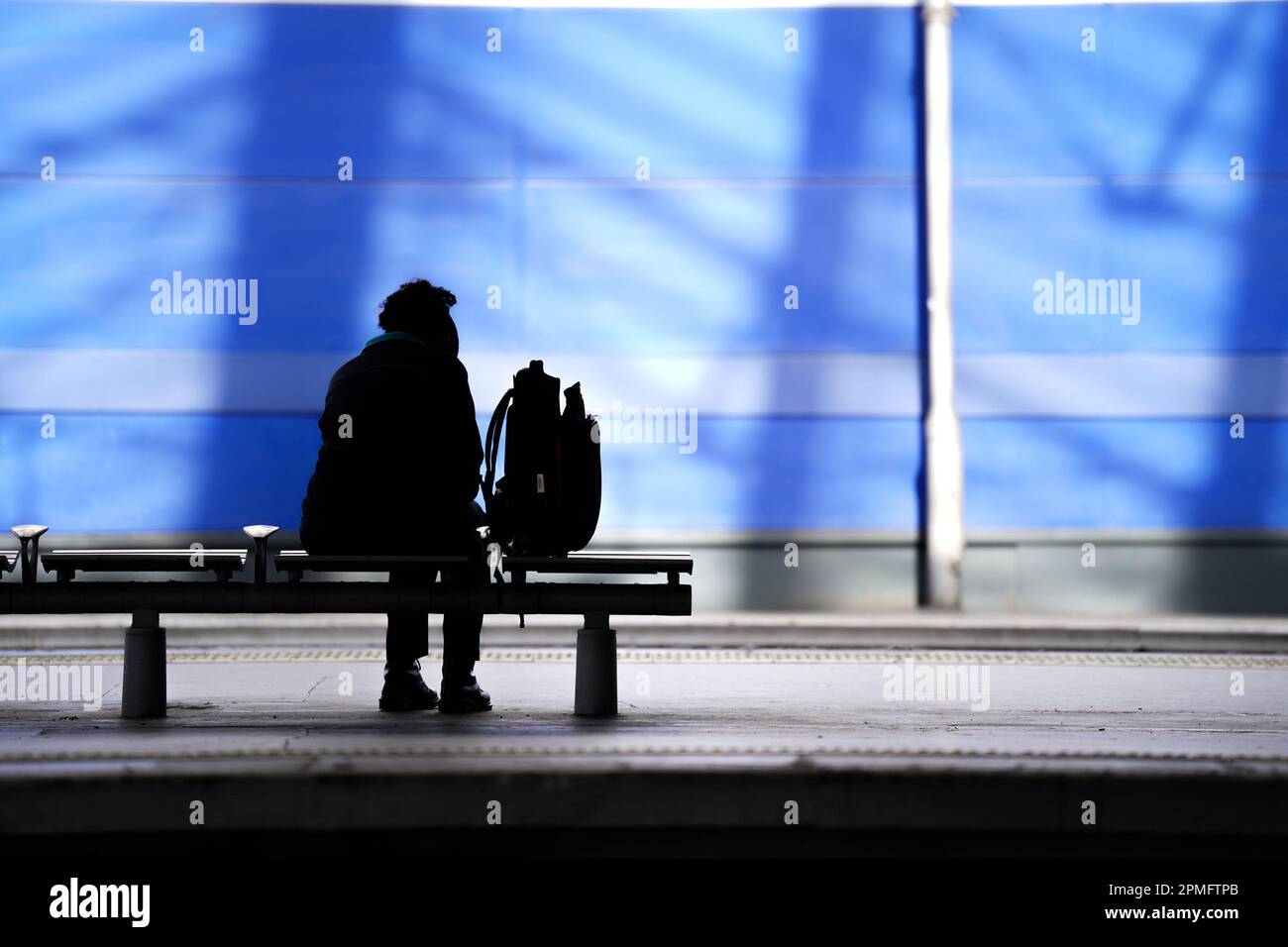 A person sits on a bench in London Waterloo station, London. South ...