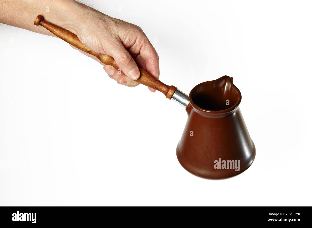 Men's hand holding coffee turk isolated white background. Clay cezve ...