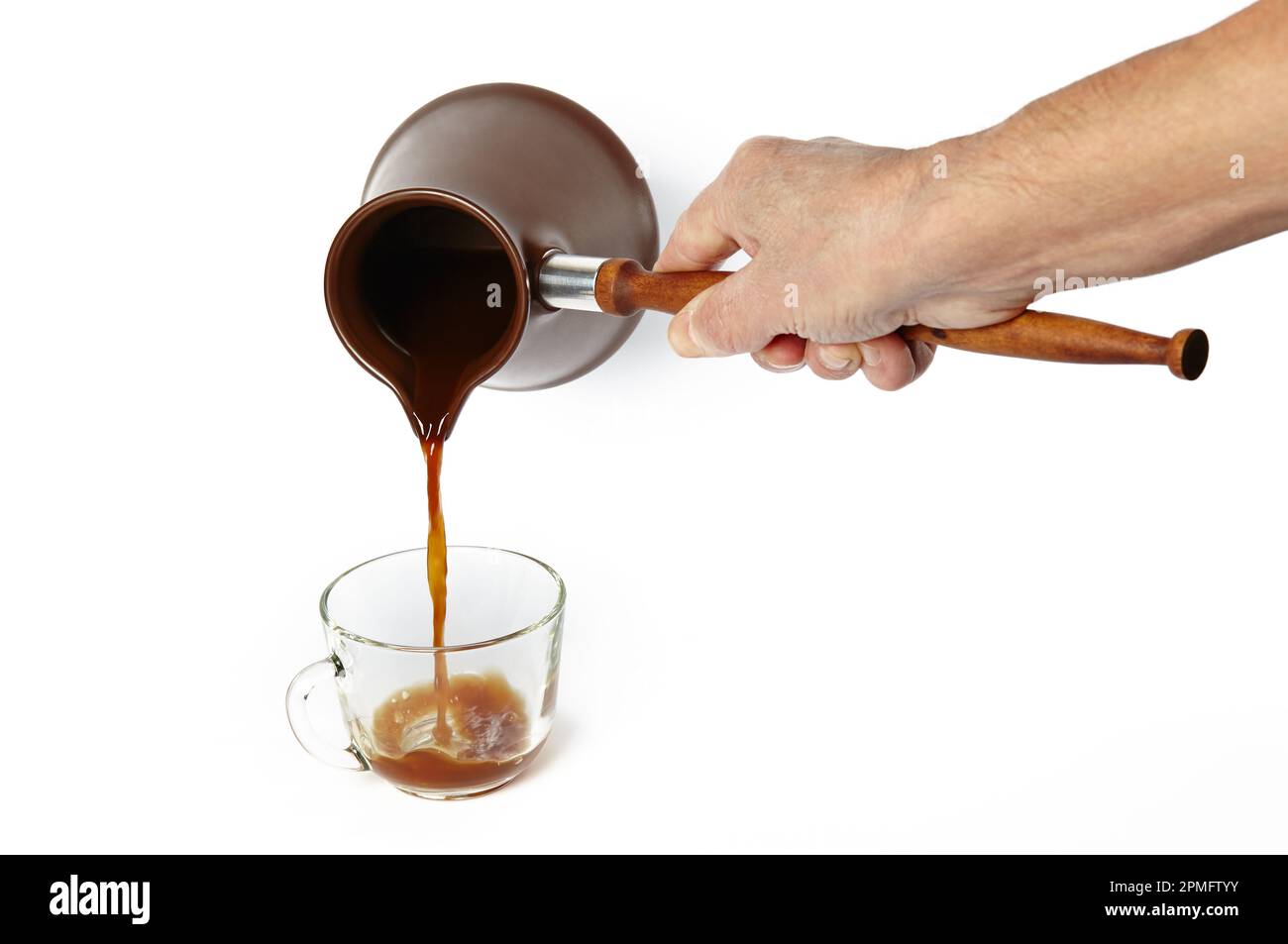 Man pouring coffee into cup isolated white background. Clay cezve for ...
