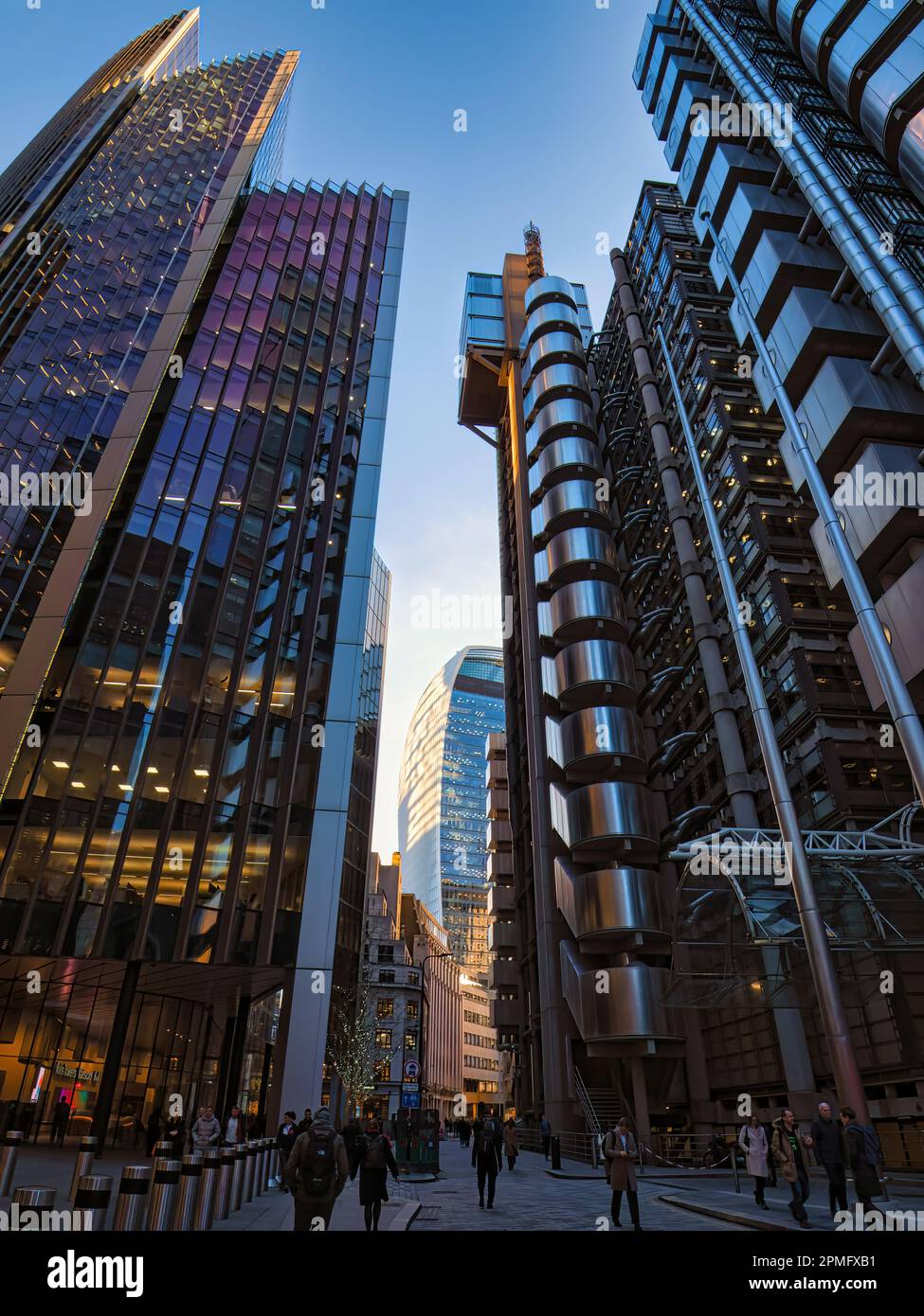 Workers head home in London's financial district. Towering overhead are ...