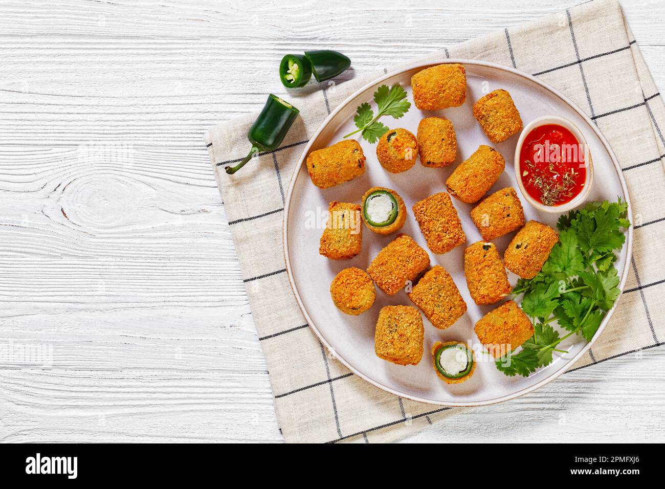 crispy fried jalapeno poppers with melted cream cheese filling on white ...