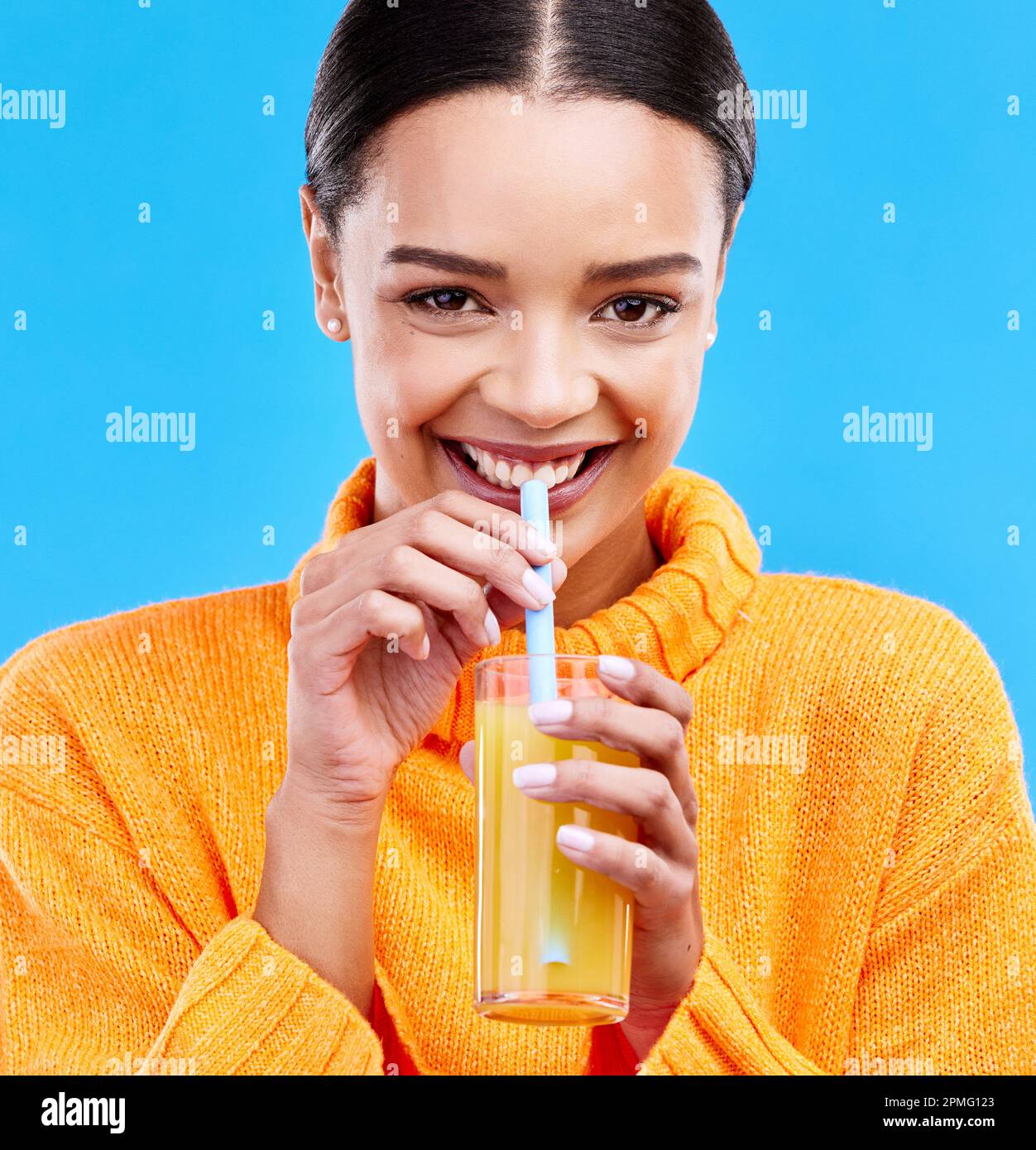 Happy woman, portrait and straw for drinking orange juice in studio ...