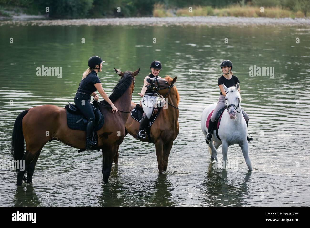 Three young women enjoying equestrian leisure, nature, and river ...