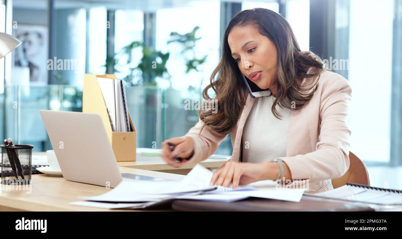 Female advertising agent looking busy while talking on a phone call and ...