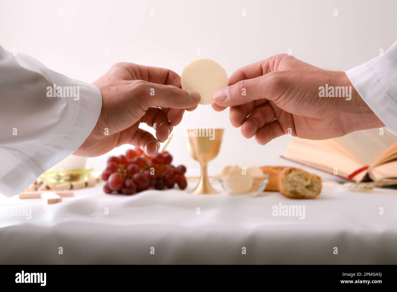 Hands of a priest consecrating a host as the body of Christ to ...
