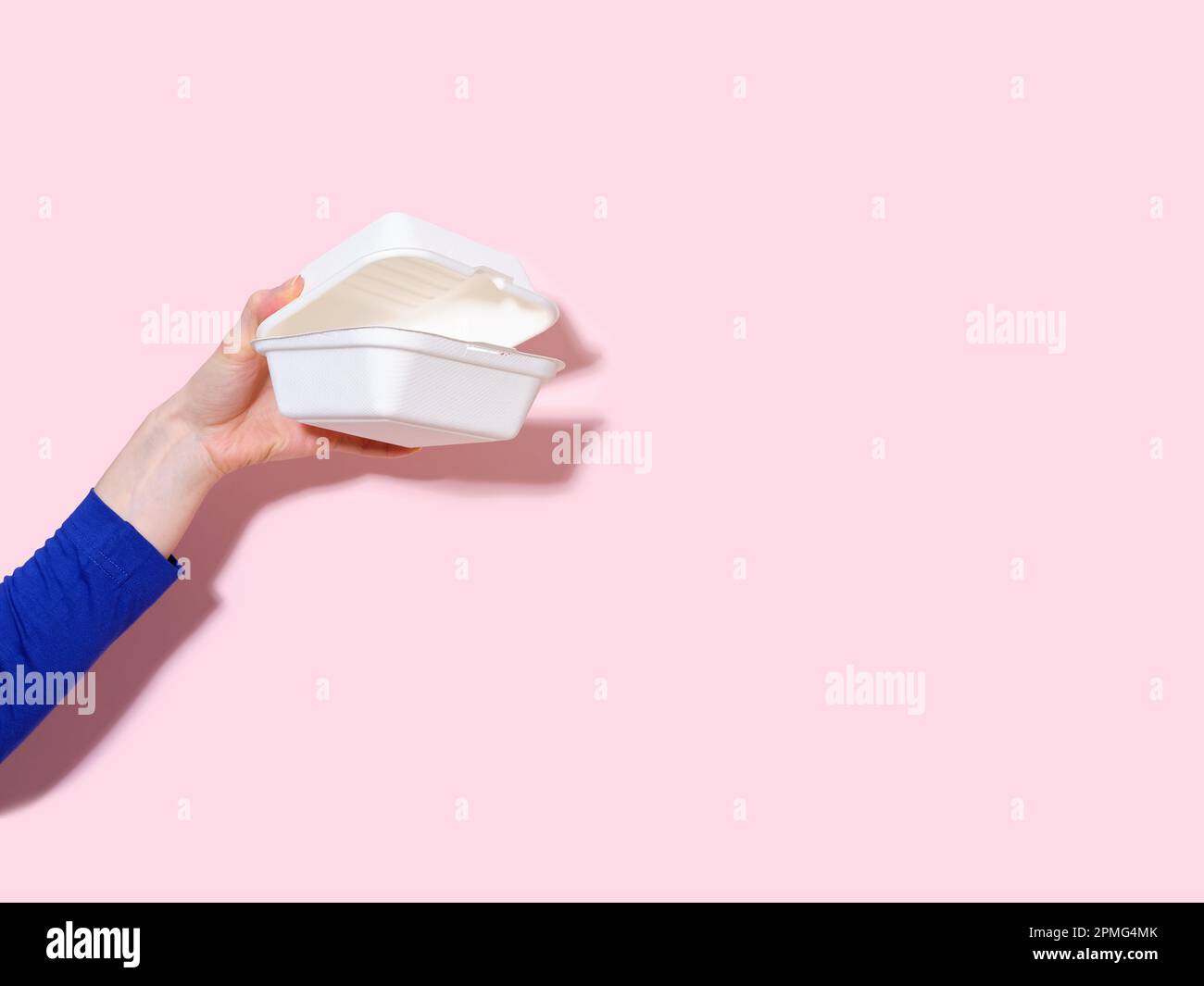 Female hand holding food container for takeaway burger. Flash light ...