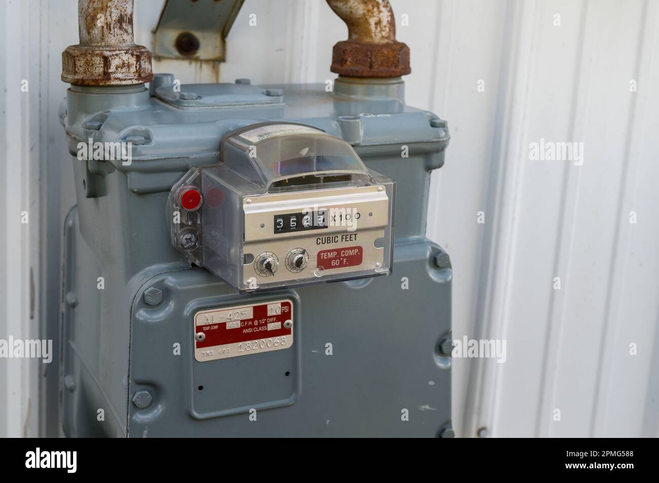 A residential gas meter located on an outside wall with copy space ...