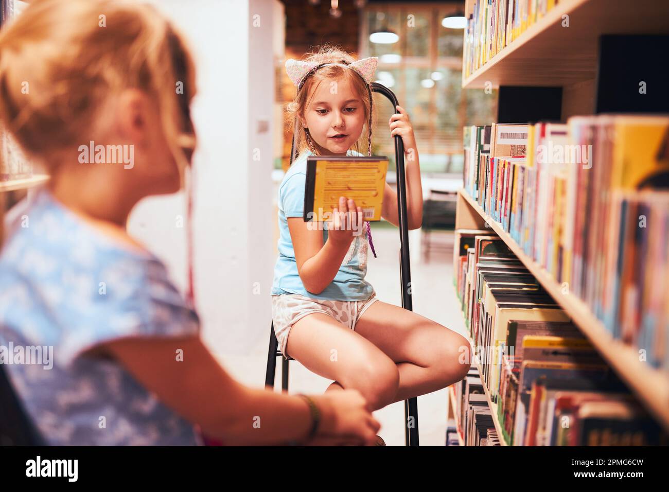 Schoolgirls looking for audio books in school library. Students ...