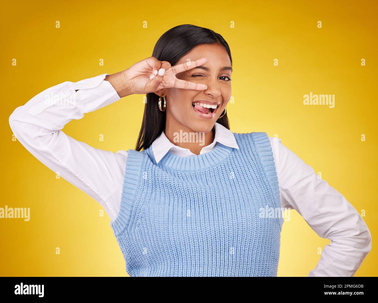 Peace sign, hands and portrait of Indian woman wink in studio for ...