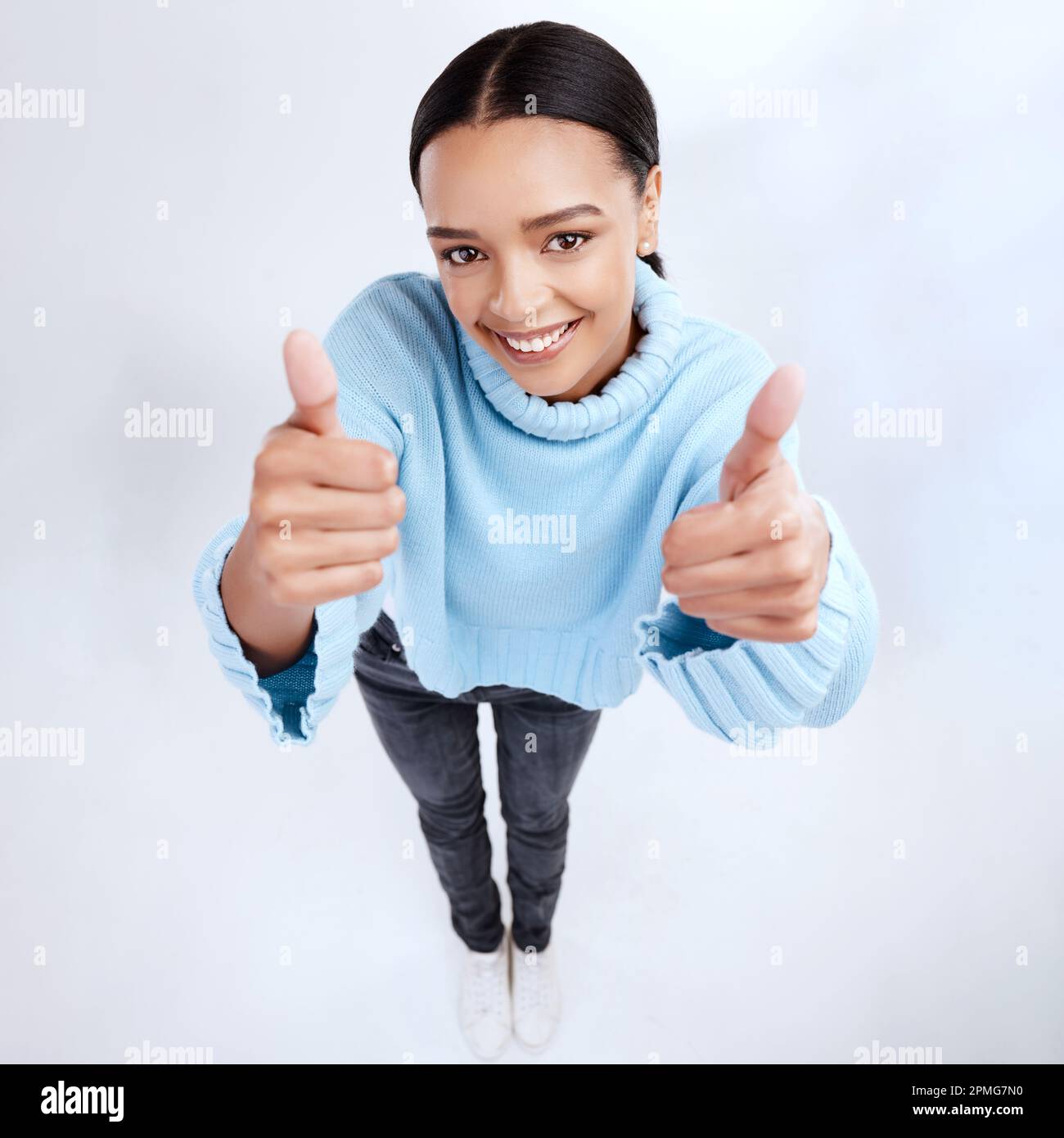 Thumbs up, portrait and top view of happy woman in white background ...