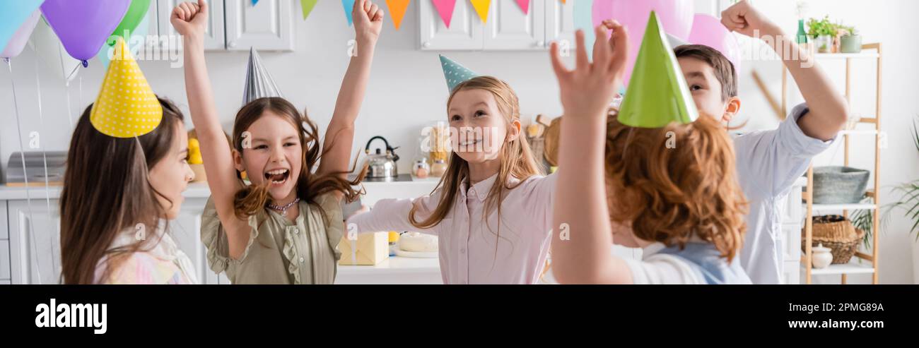 excited children in party caps having fun during birthday celebration ...