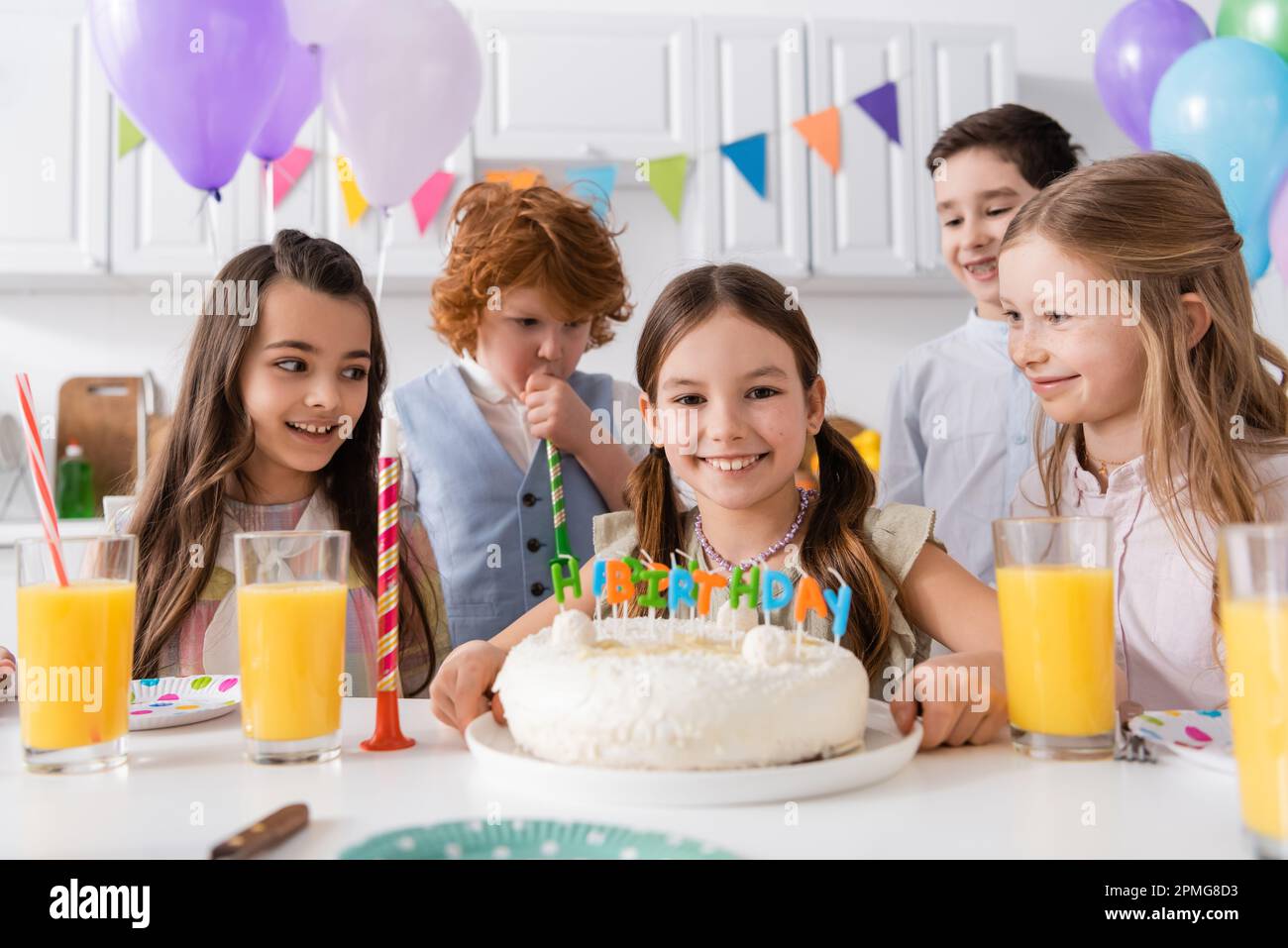 group of happy preteen kids celebrating birthday next to tasty cake ...