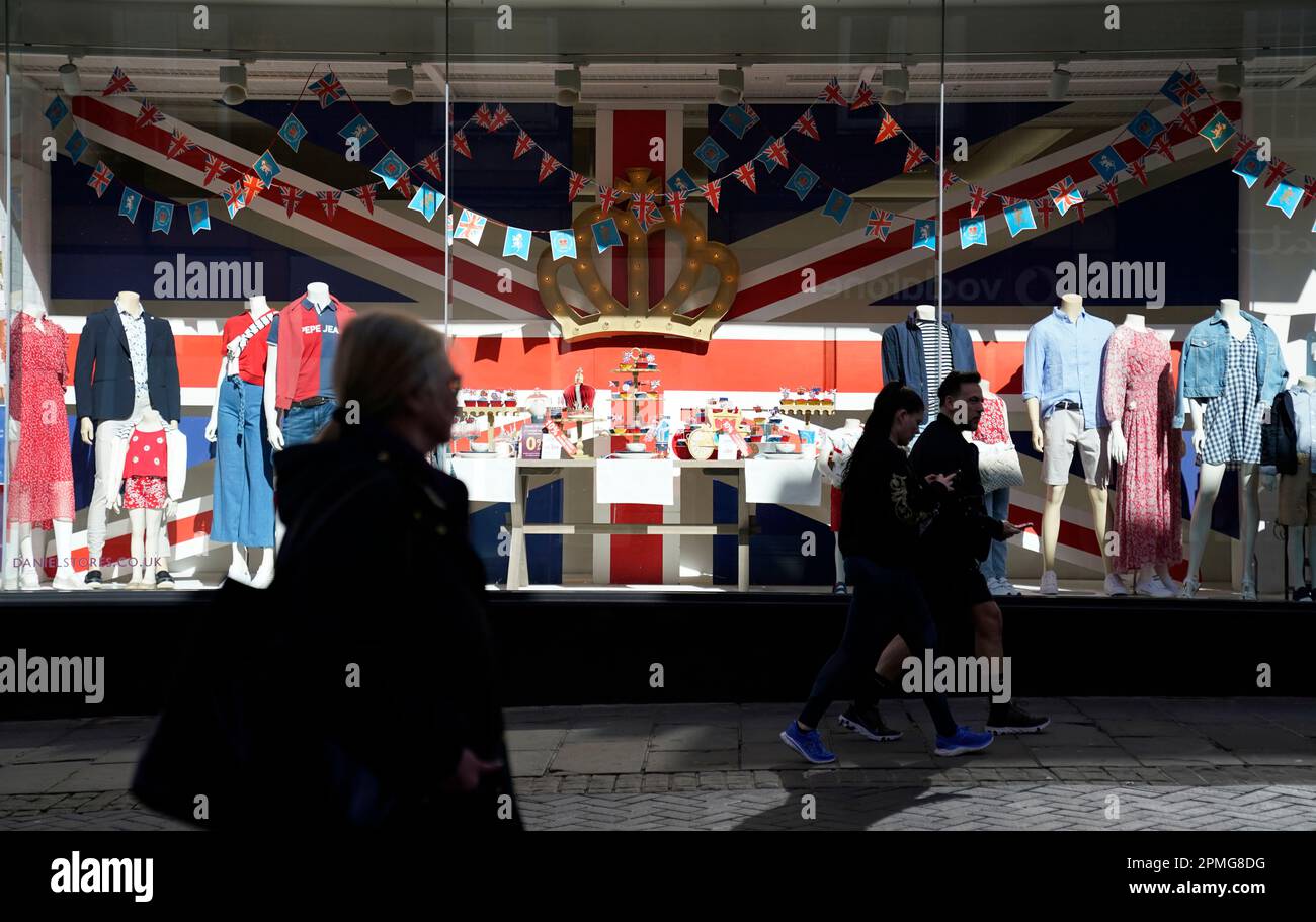 People walk past a coronation display inside the shop window of Daniel ...