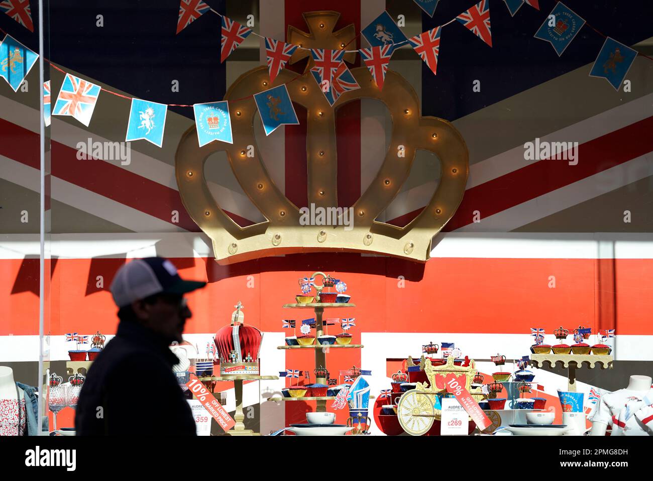 People walk past a coronation display inside the shop window of Daniel ...