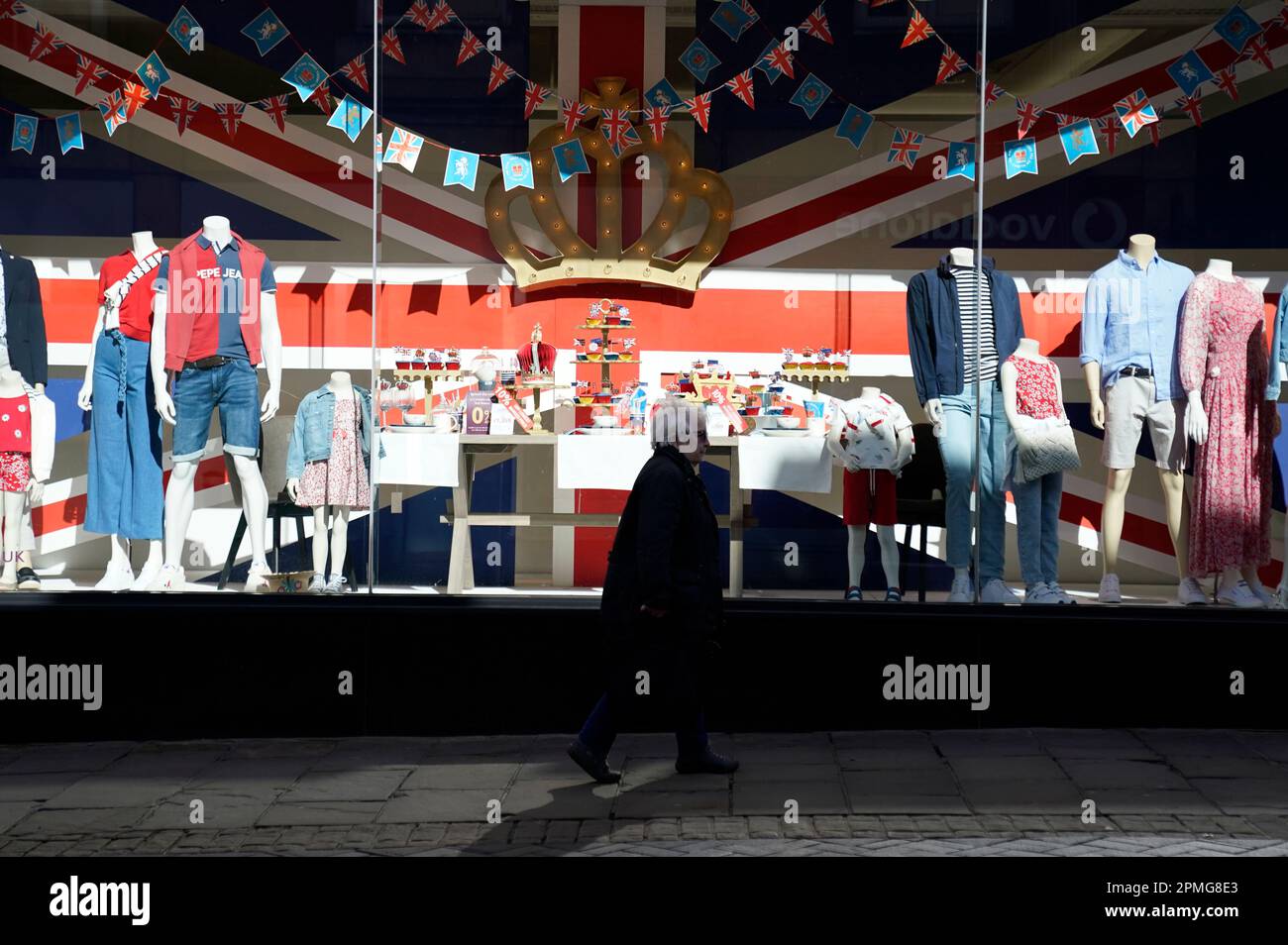 A person walks past a coronation display inside the shop window of ...