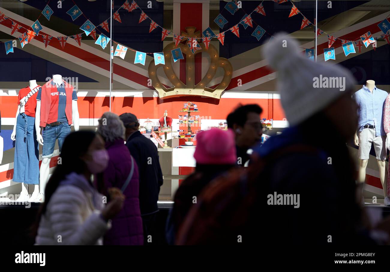 People walk past a coronation display inside the shop window of Daniel ...