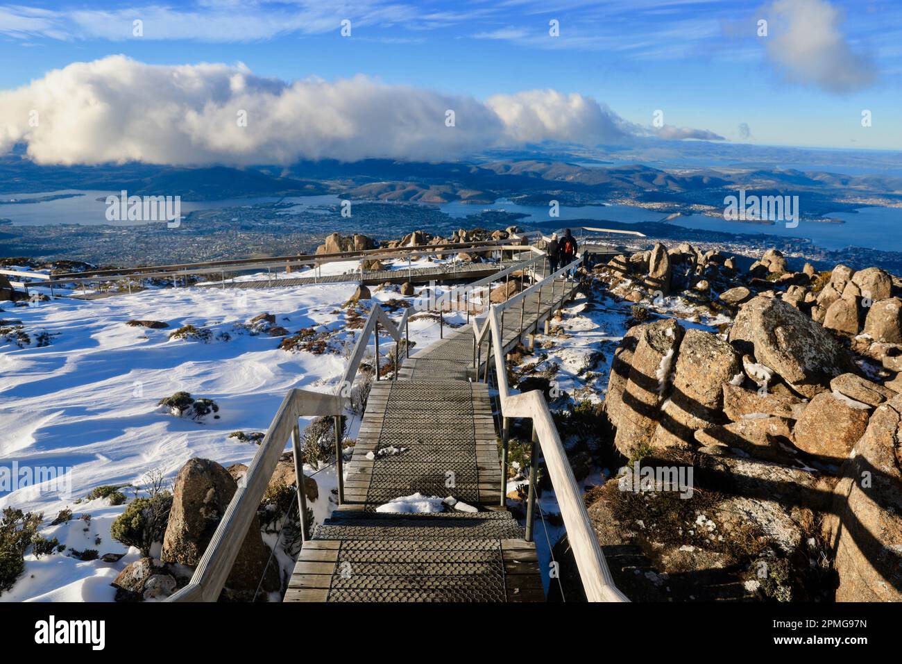 An outdoor staircase leading up a snow and rock-covered hill in a ...