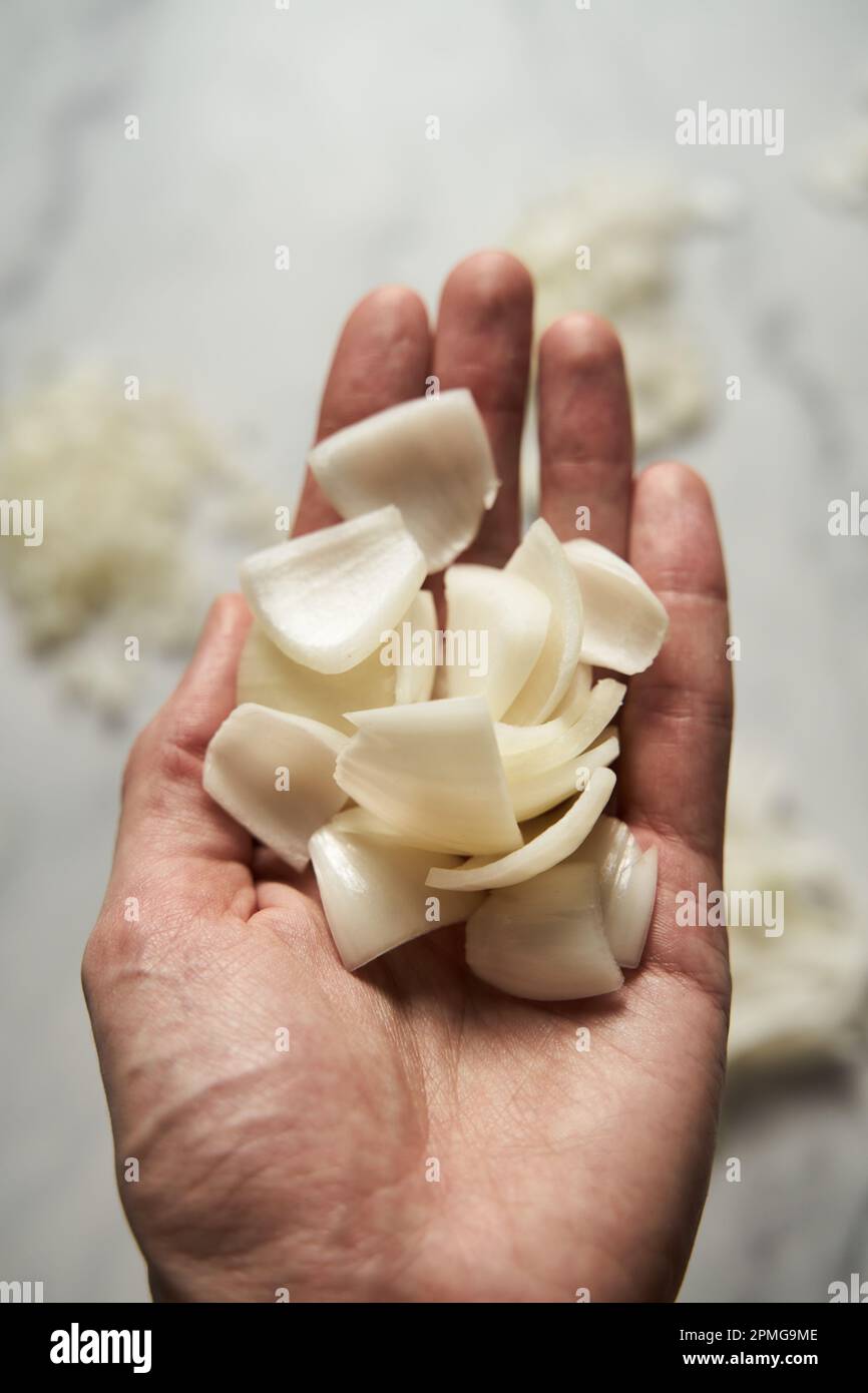 Chunk sliced onions on mans hand. Photo show how does onion sliced into ...