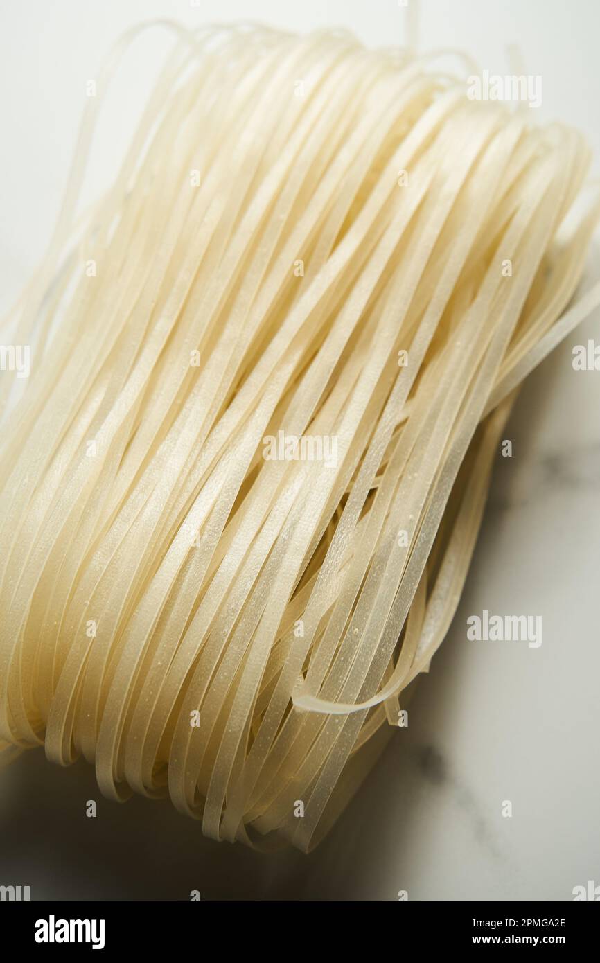 Wide rice noodle on white and clean marble background. Raw and uncooked ...