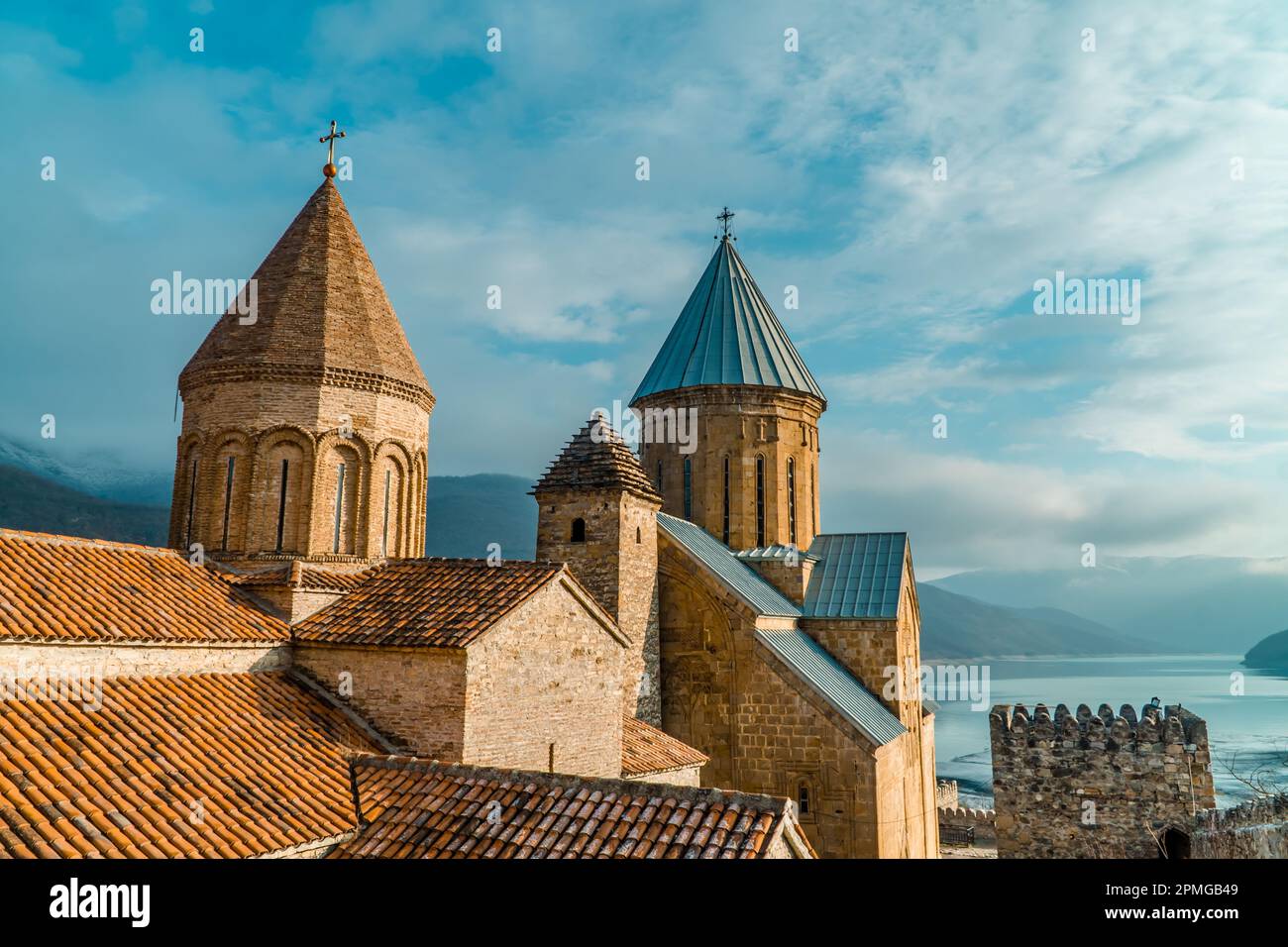 The historic 13th-century Ananuri Fortress under a bright blue sky in ...