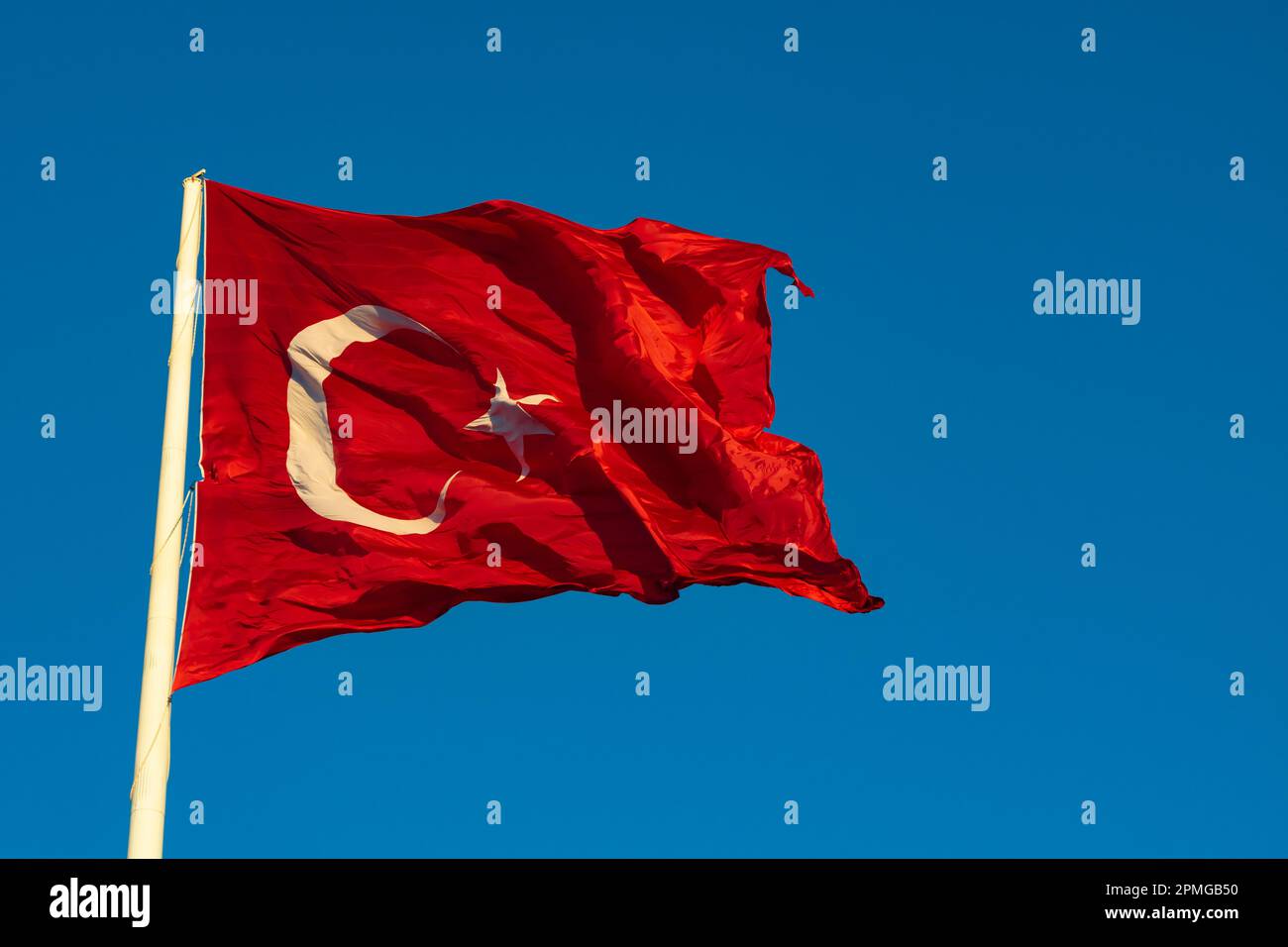 Waving Turkish Flag at sunset isolated on blue sky background. Public ...