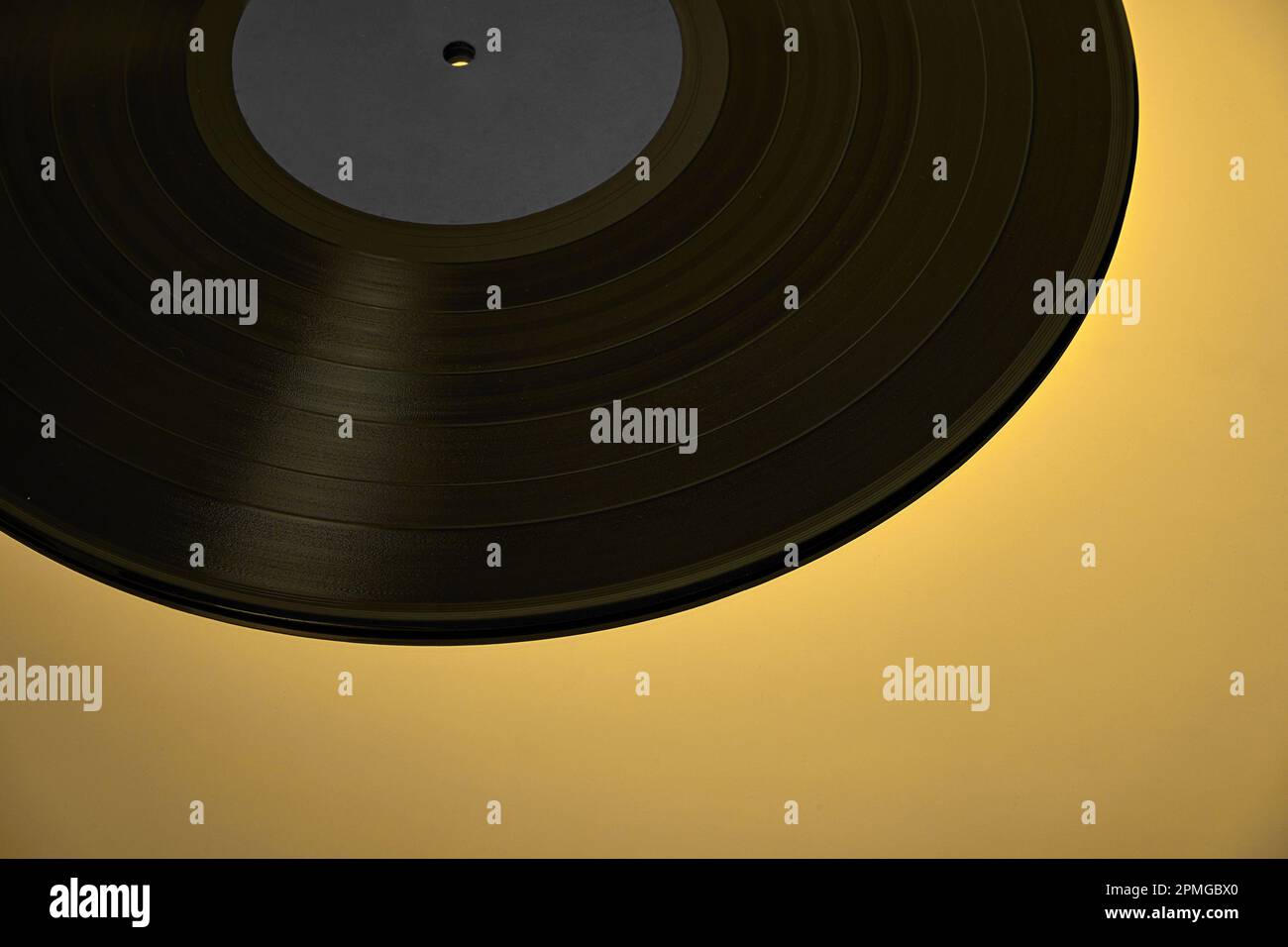 A vinyl record with a red border resting atop a light-colored ...