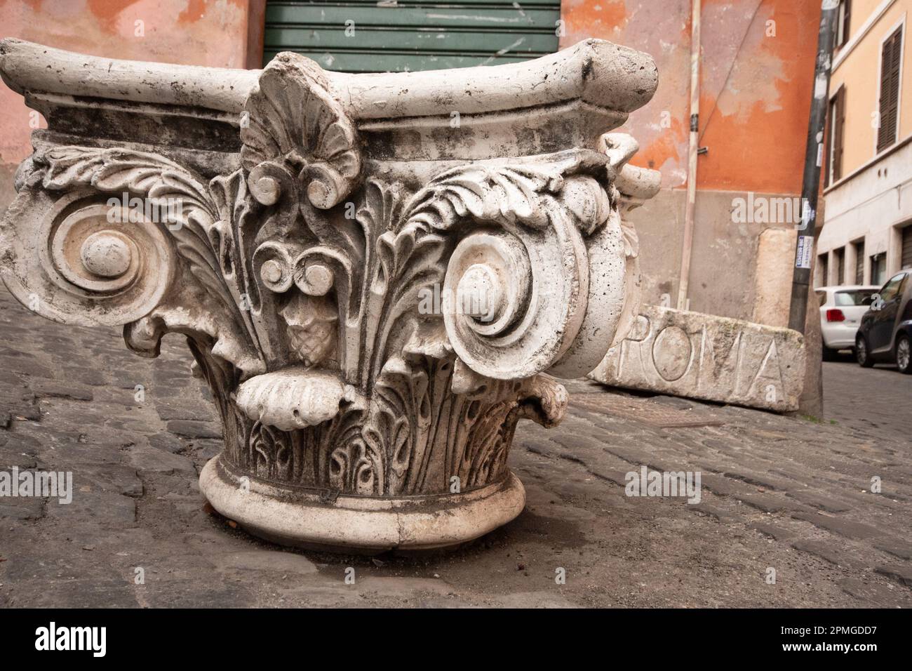 Column's capital or similar roman artefact abandoned on a street corner ...