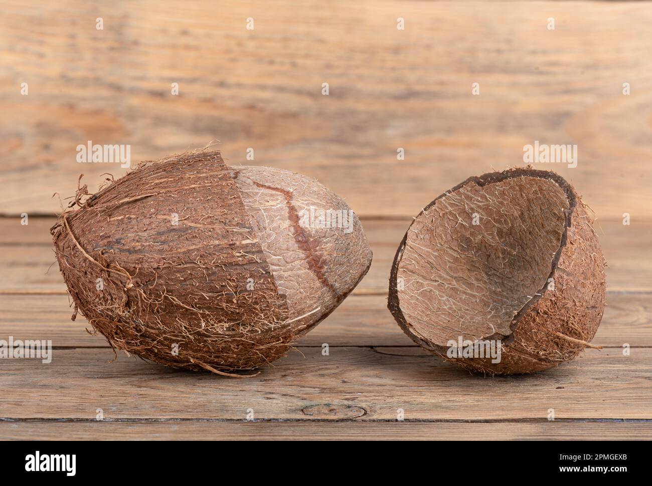 The core of a coconut in a split shell on a wooden background. Copy ...