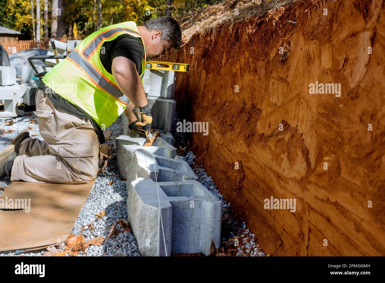 Contractor is constructing block retaining wall on construction site ...