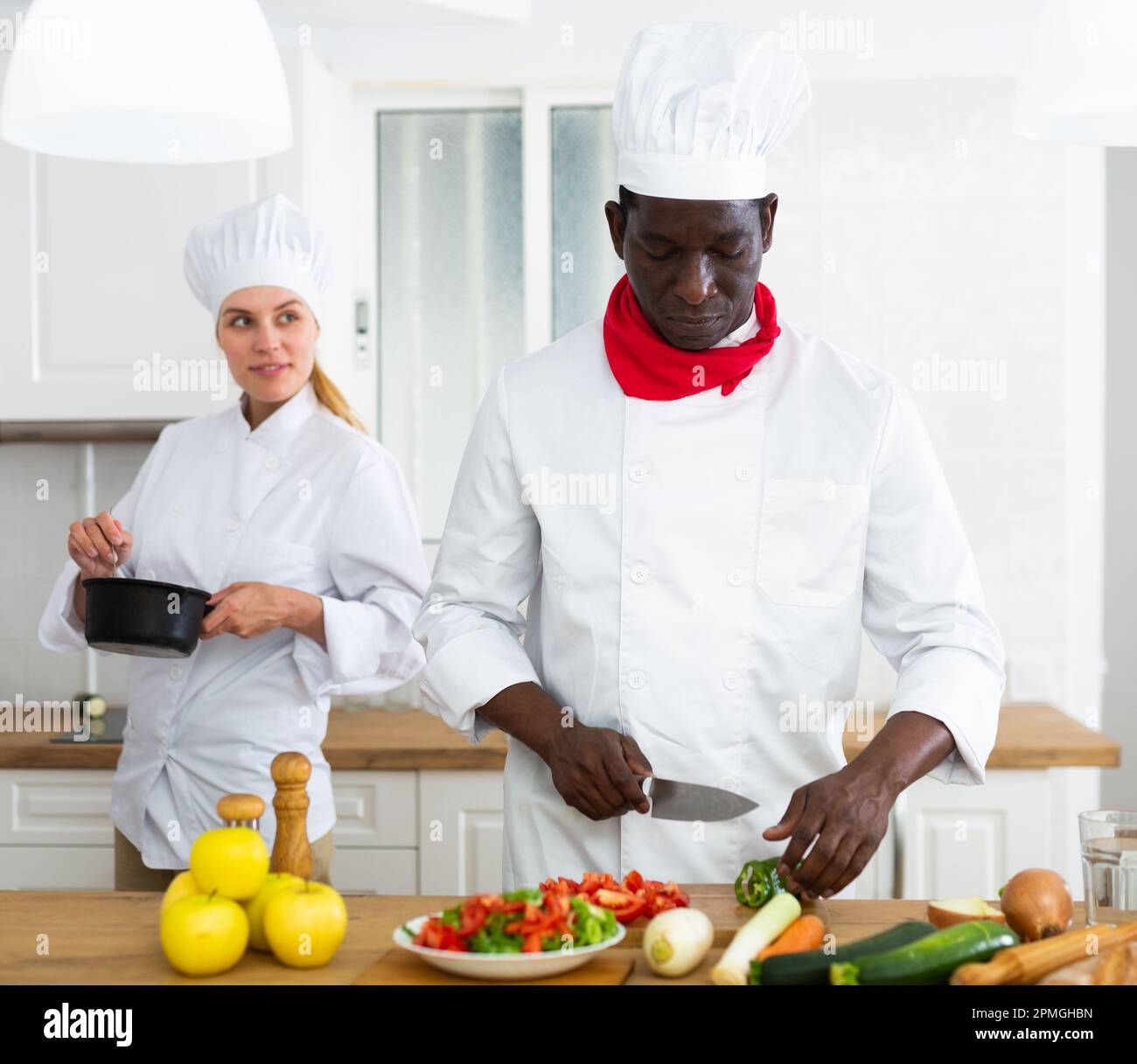Chef and cook preparing food together Stock Photo - Alamy
