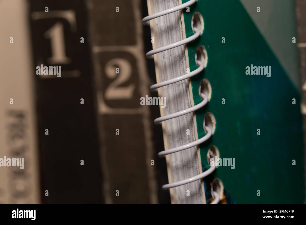 A spring-loaded notebook among old brown book volumes, close-up macro ...