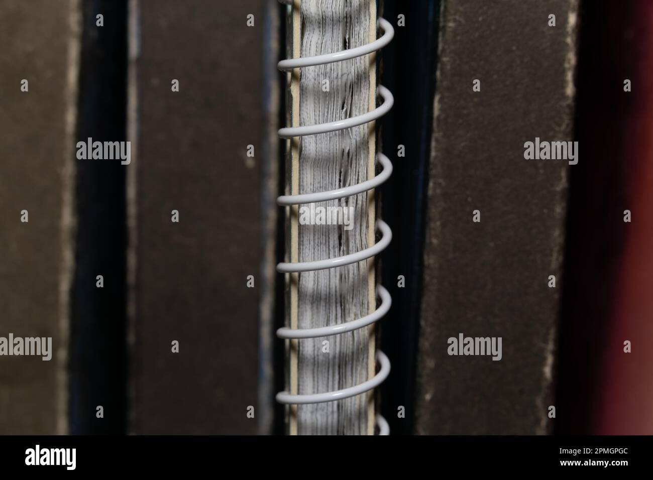 A spring-loaded notebook among old brown book volumes, close-up macro ...