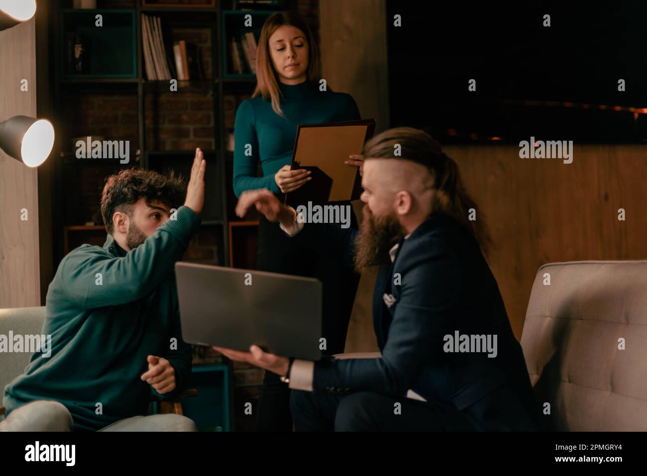 Three coworkers working remotely. Two male people giving high five to ...