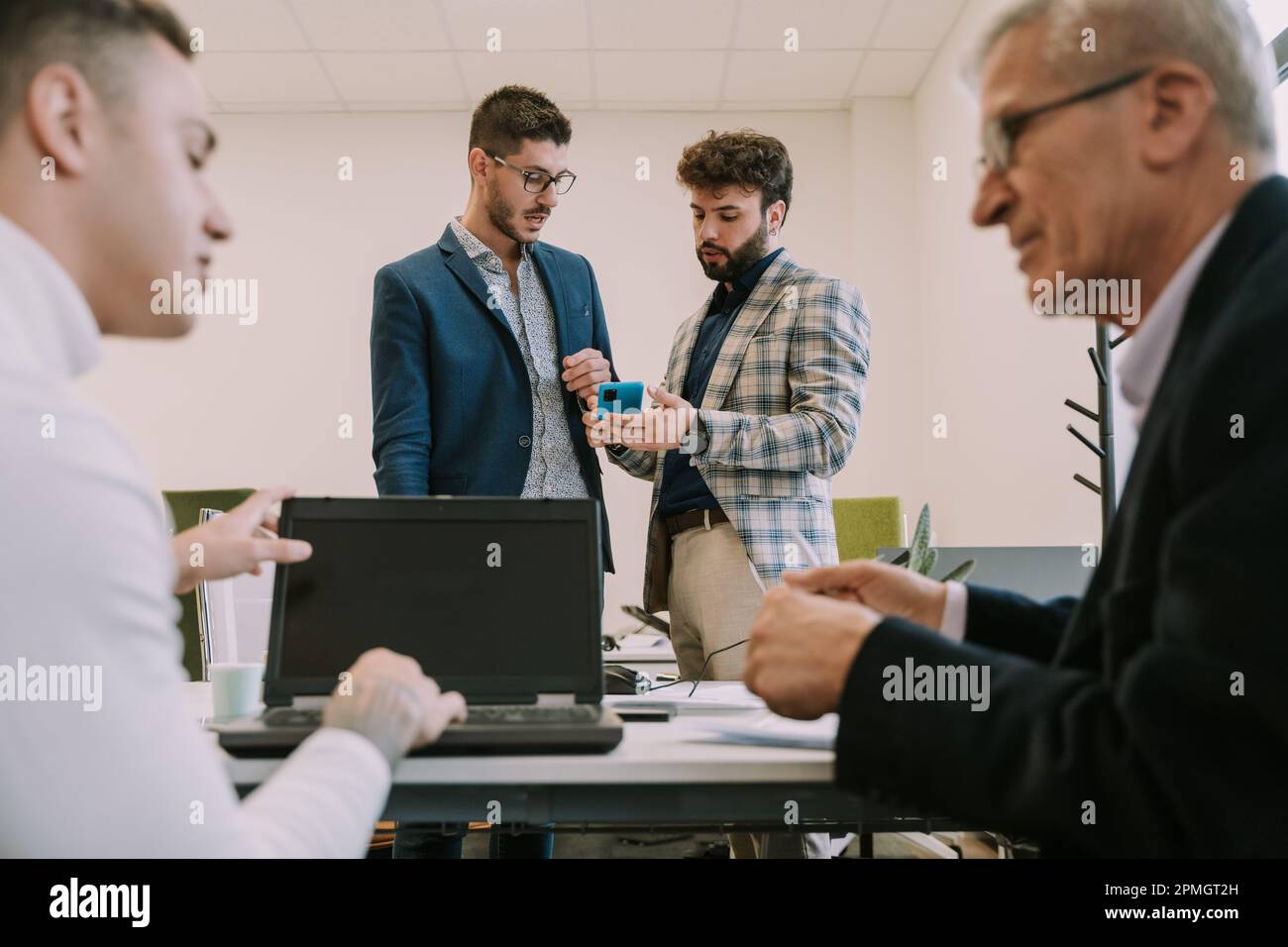 Smart eccentric businessman is showing his partner the background for ...