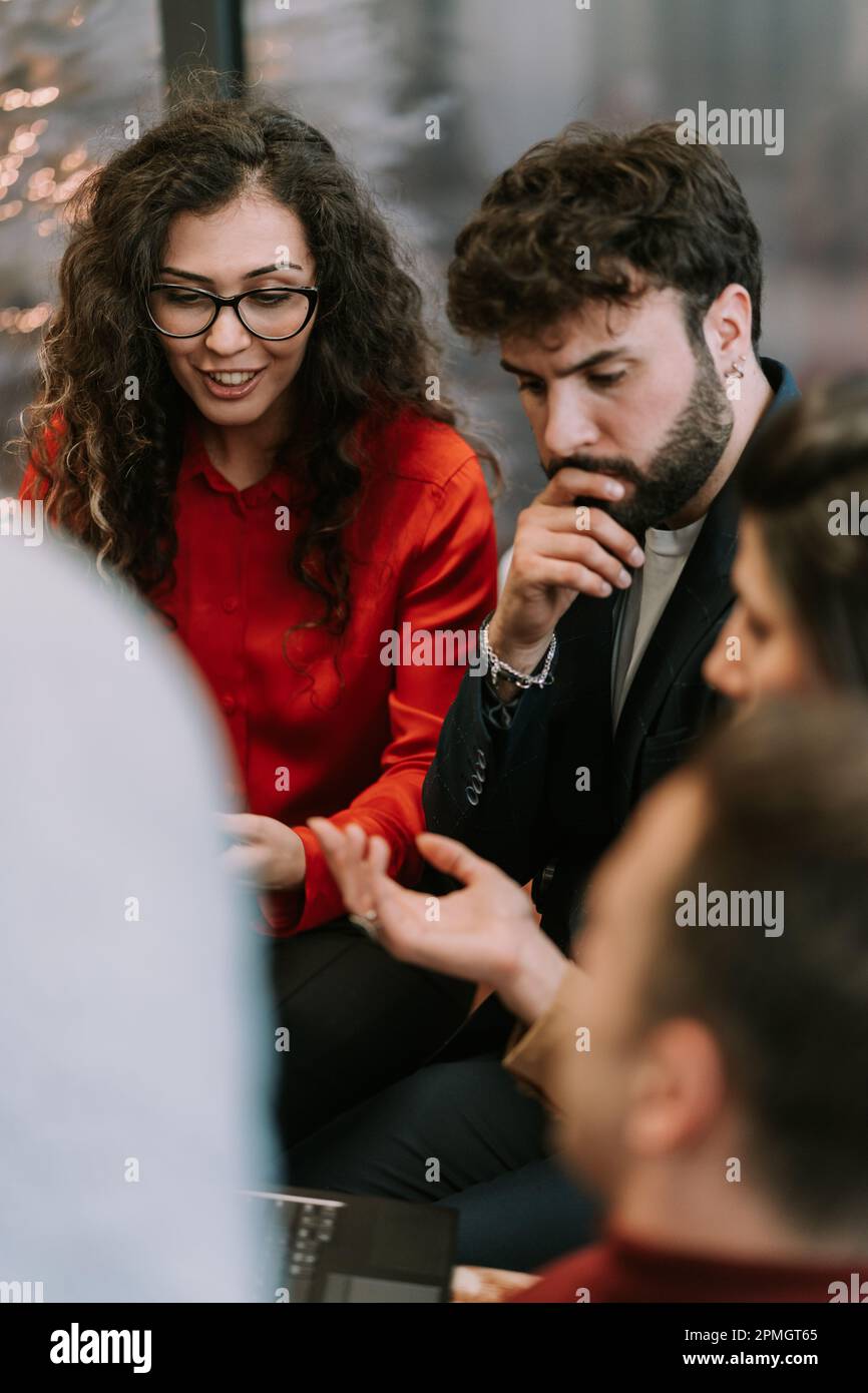 Beautiful colleagues, a couple, looking at the lap top while their ...