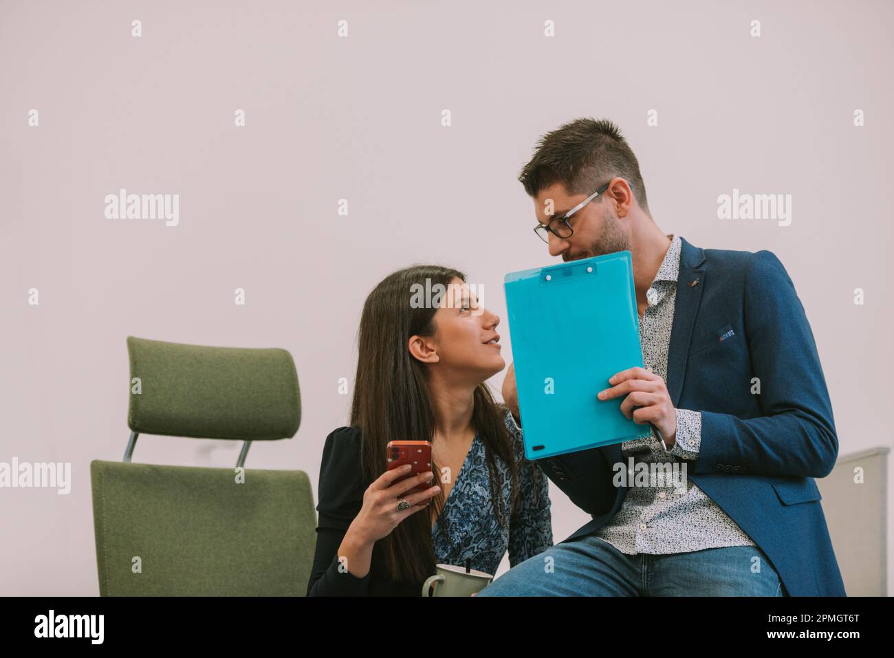 Two business partners talking to eachother while sitting at the co ...