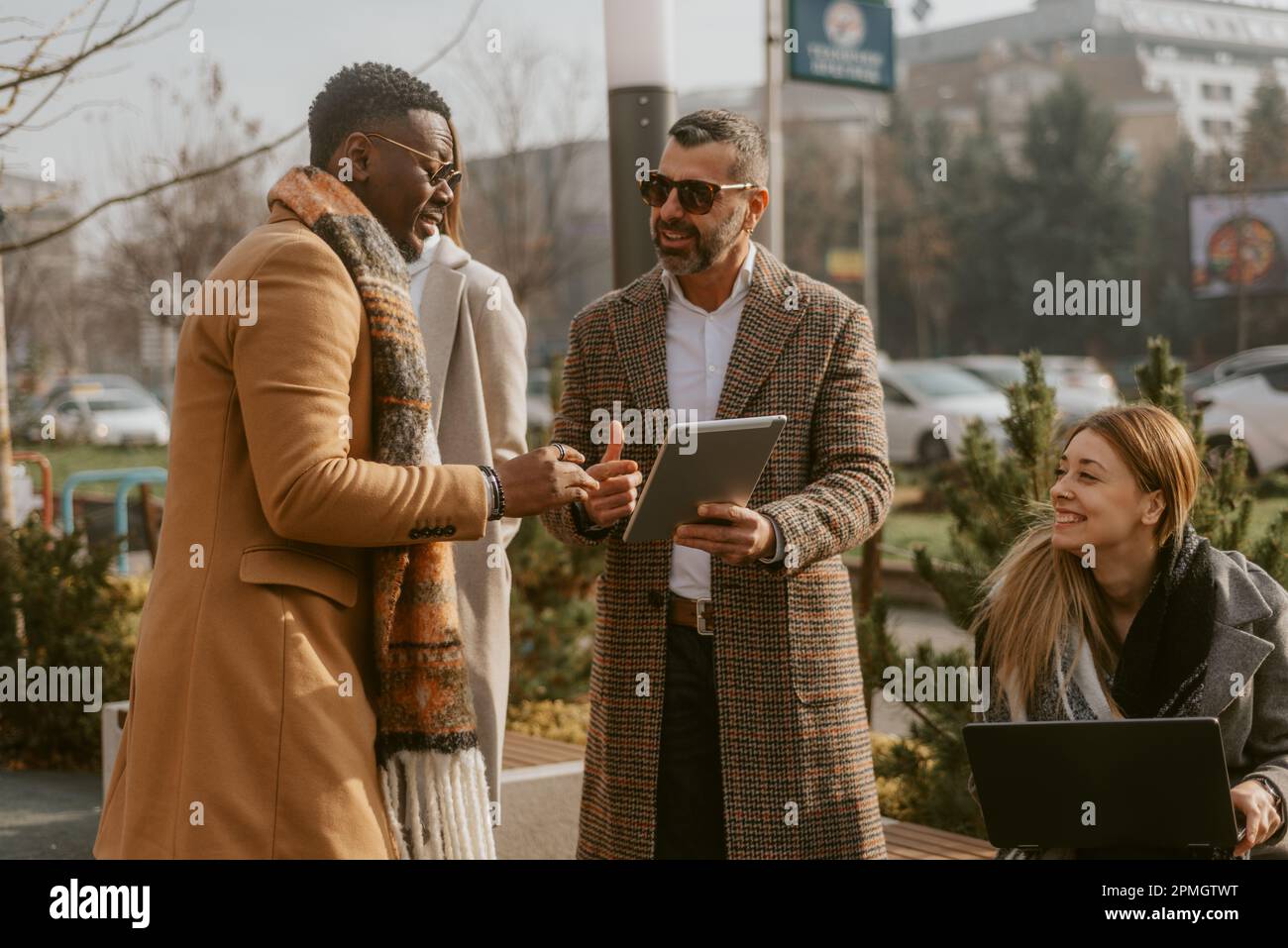 Four business colleagues smiling and working together at the park Stock ...