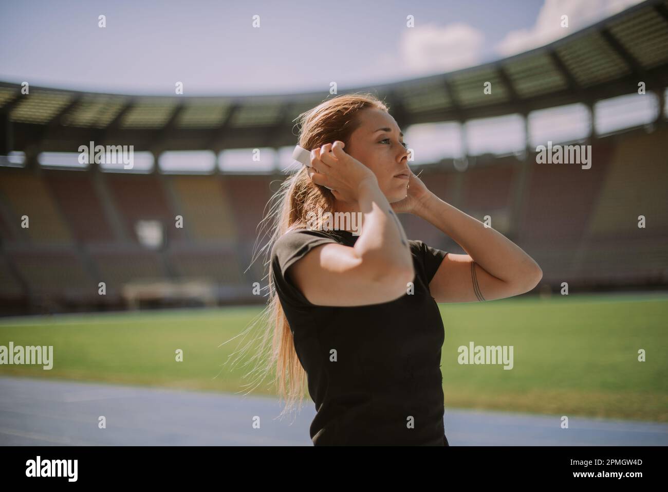 Beautiful female sportsperson is about to run on a stadium's track. She ...