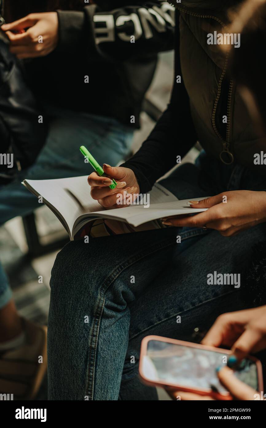 Girl writing notes down in a notebook. Close up shot Stock Photo - Alamy
