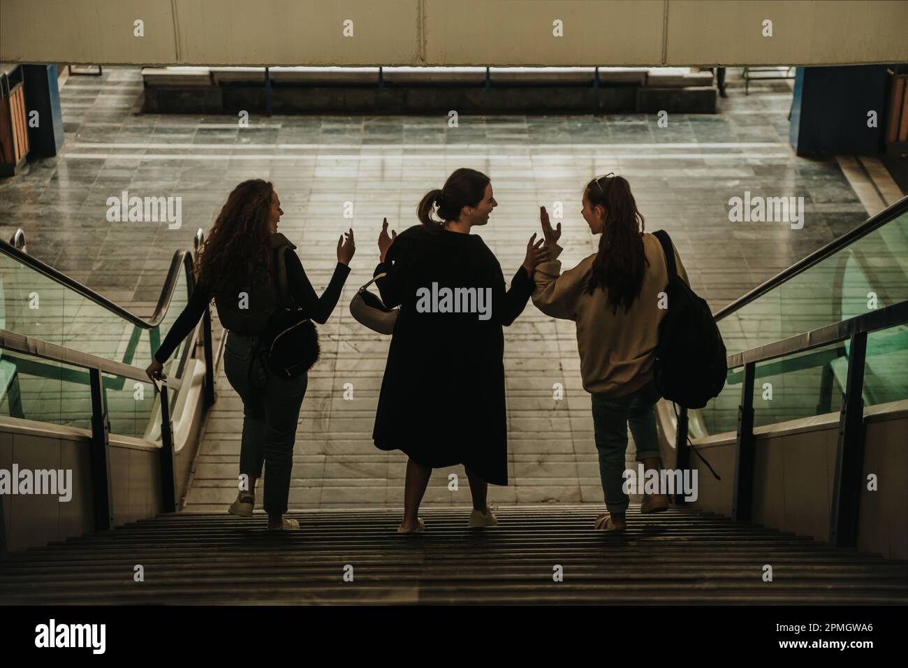 Back view shot of three female friends having fun conversation and ...
