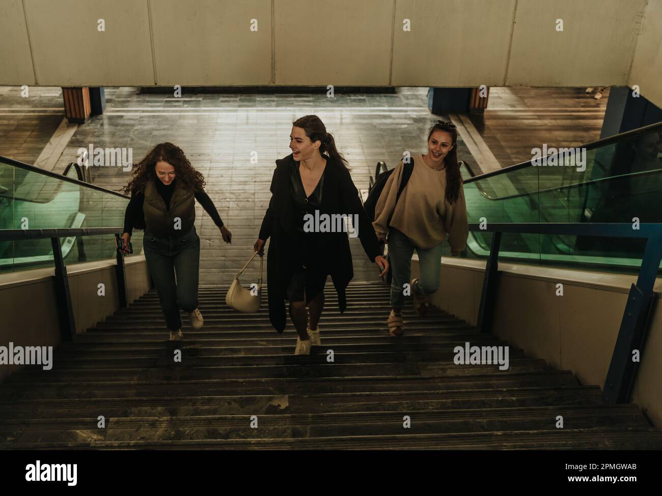 Three girls are about to go shopping. They are walking upstairs ...