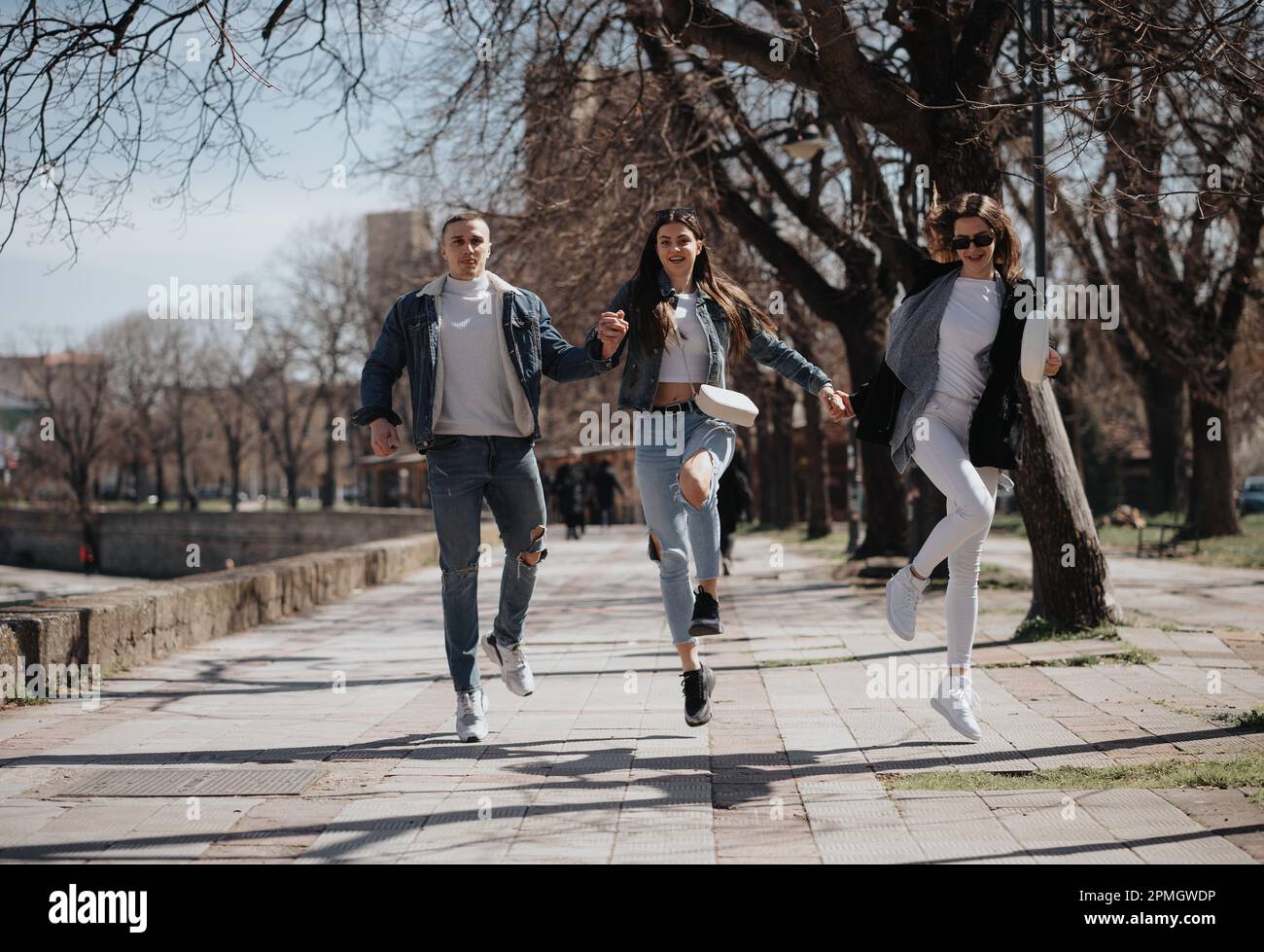 Three close friends running and jumping and having a good time at the ...