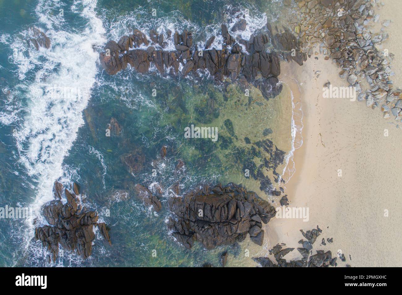 Overhead view of a beach with rocks on the shore Stock Photo - Alamy