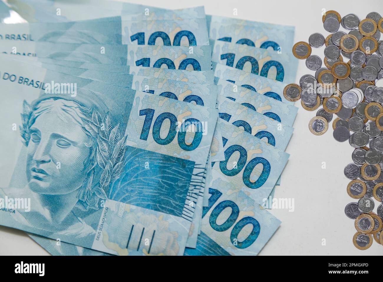 several hundred reais notes and coins from Brazil on neutral white ...