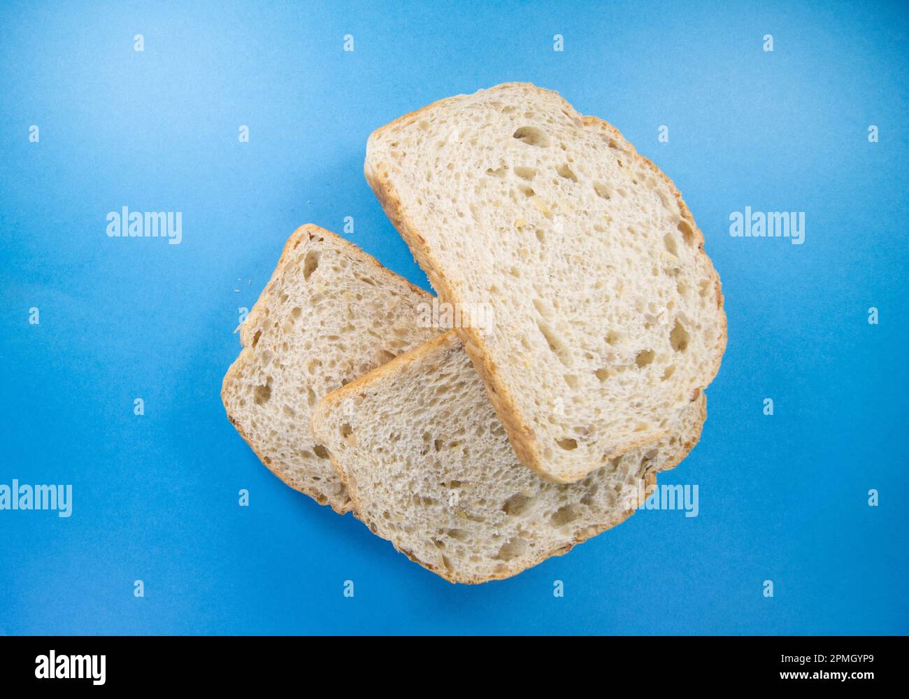 pile of three slices of fresh seeded bread isolated on a dark blue ...