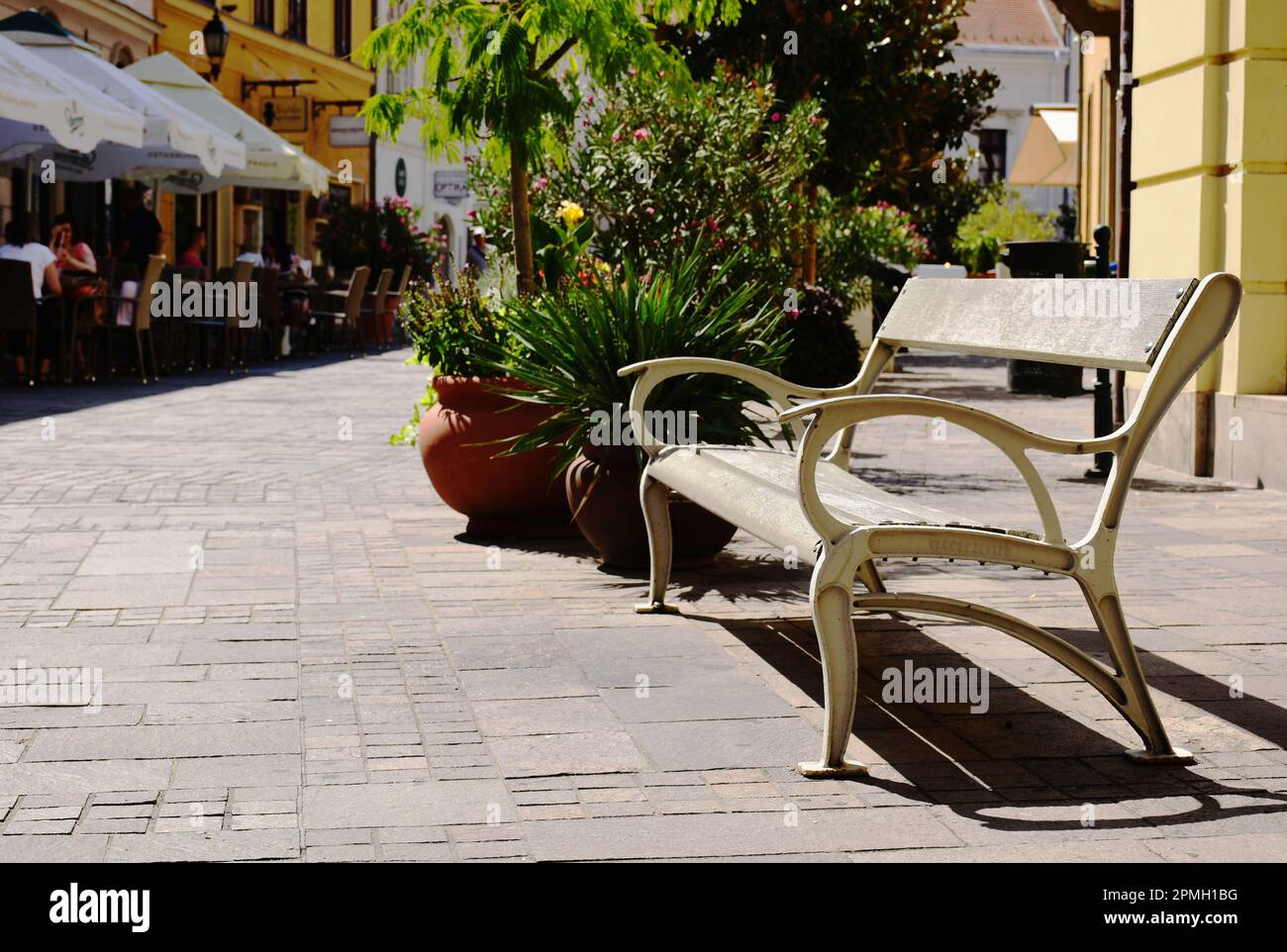 wood and cast iron vintage park bench on old european street with ...