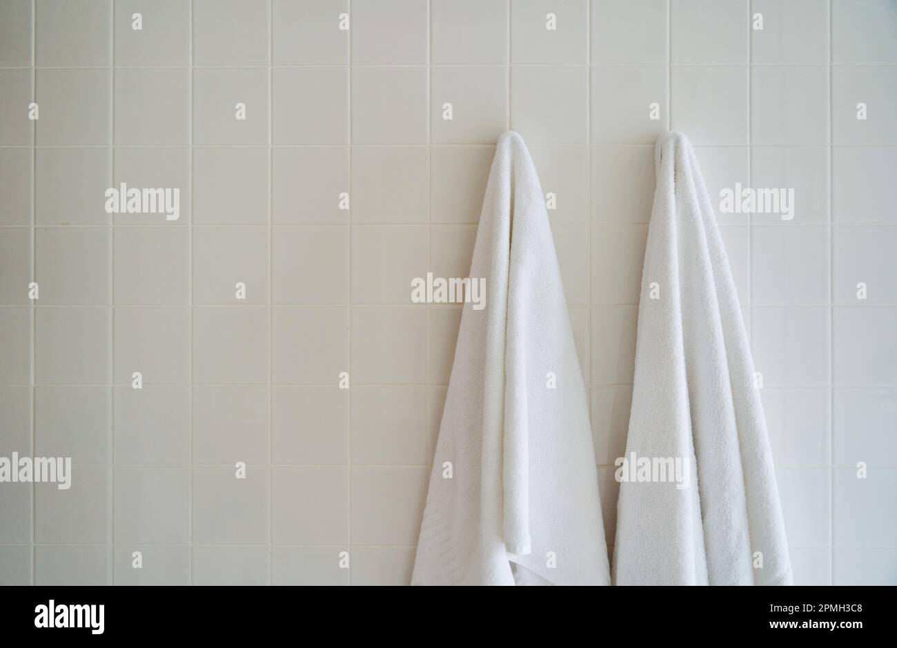 Two white towels hanging in the hotel shower room Stock Photo - Alamy